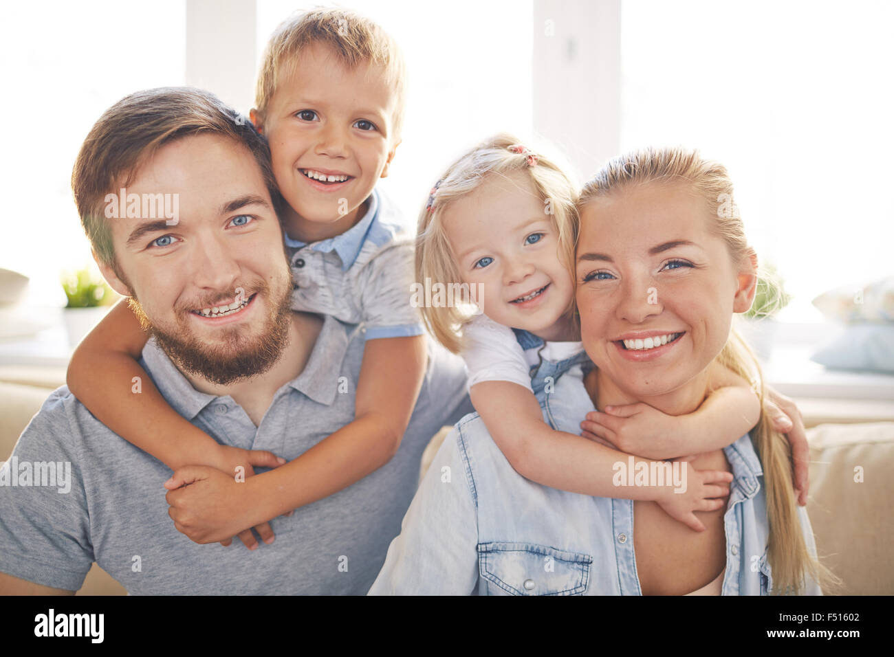 Happy kids embracing their cheerful parents Stock Photo - Alamy