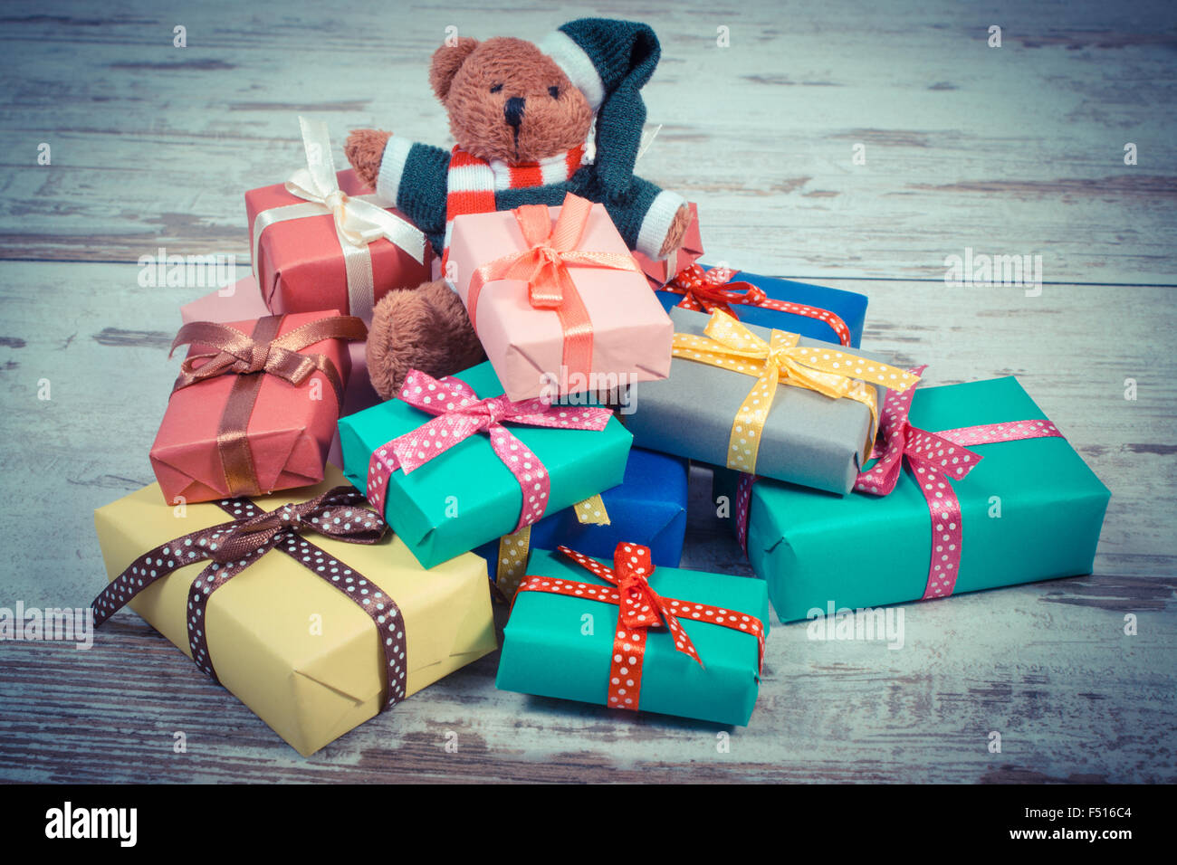 Vintage photo, Fluffy teddy bear and heap of wrapped colorful gifts for ...