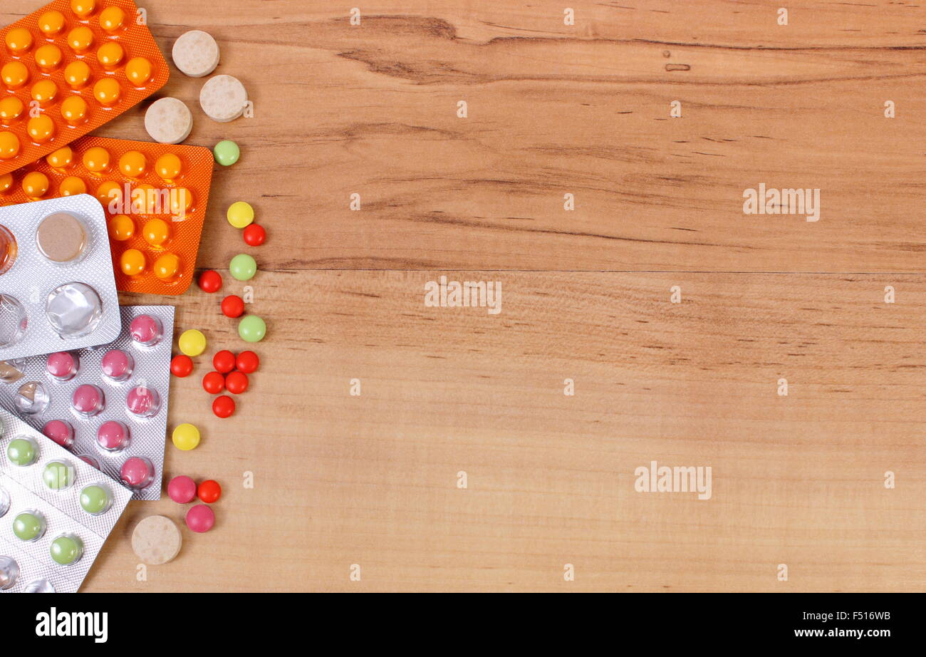 Medication for treatment of colds, flu and runny on wooden background ...