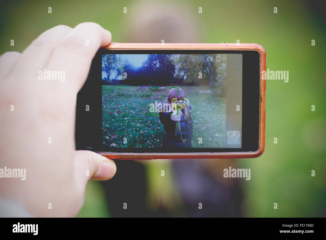 Person taking a photo with mobile photo camera, on photo little girl ...