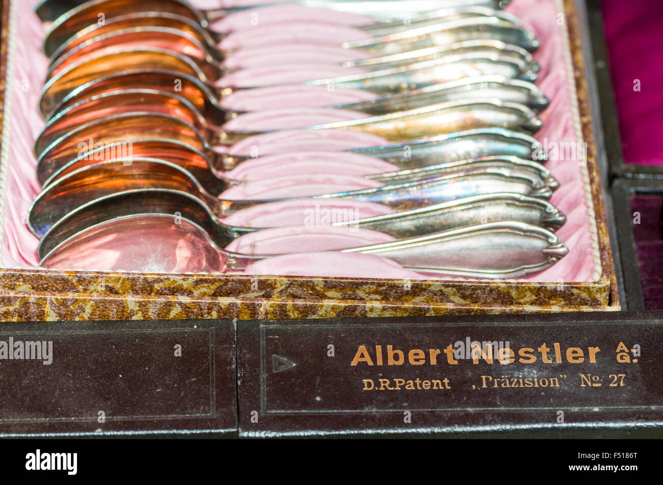 Old silver spoons in a box are offered for sale at the weekly flea ...