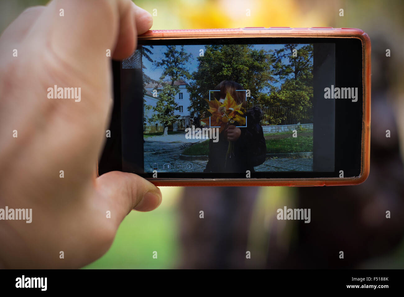 Person taking a photo with mobile photo camera, on photo little girl ...