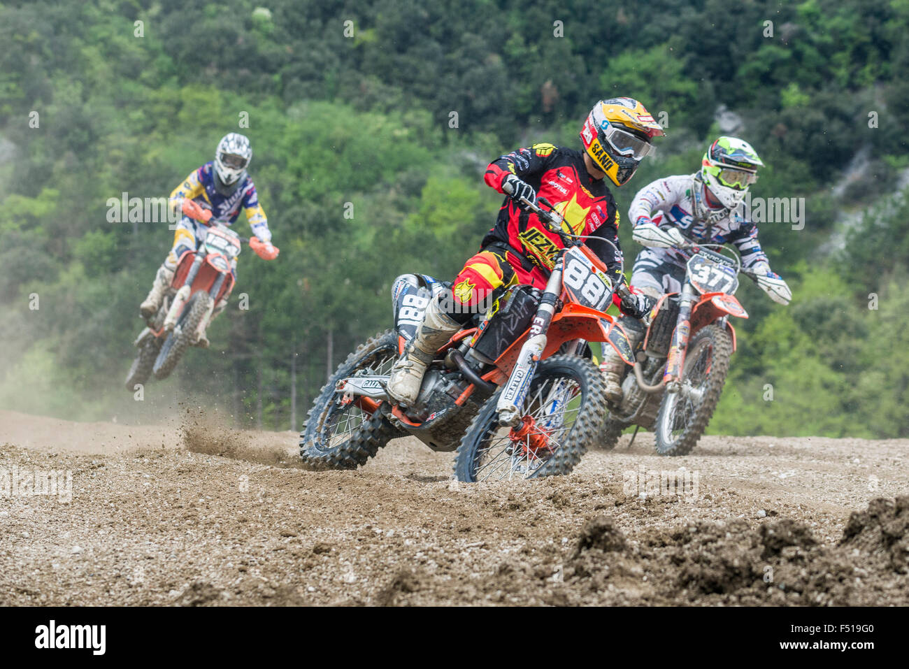 A group of motorcyclists on motocross bikes are riding on a dirt track ...