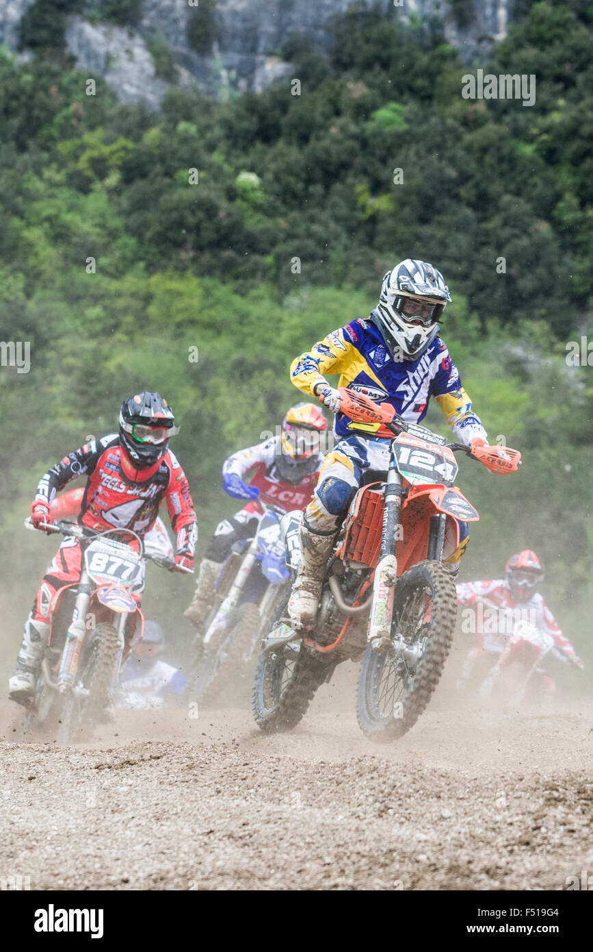 A group of motorcyclists on motocross bikes are riding on a dirt track ...