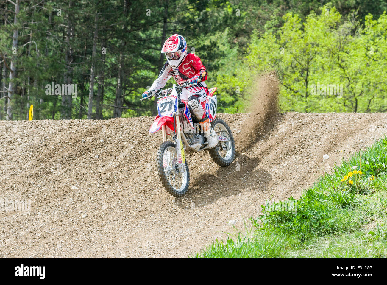 A motorcyclist on a motocross bike is riding on a dirt track during ...
