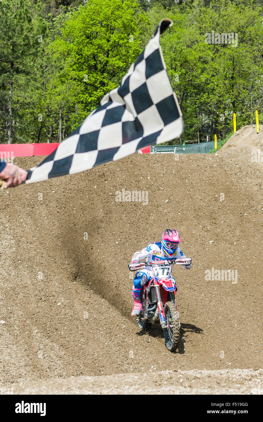 A motorcyclist on a motocross bike is riding on a dirt track during ...