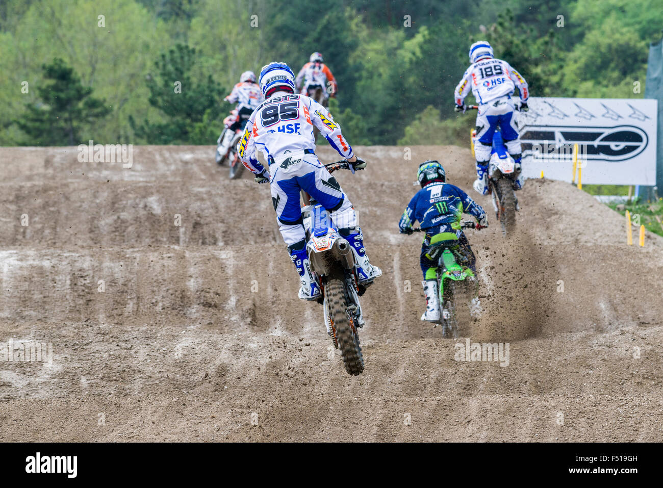 A group of motorcyclists on motocross bikes are riding on a dirt track ...