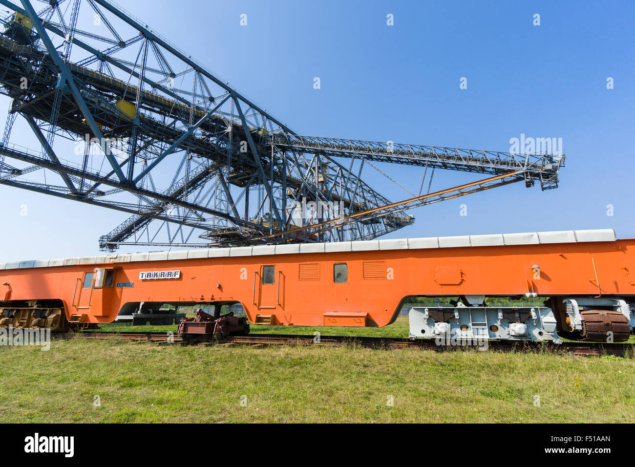 An orange Track Moving Machine of the company Takraf, used in brown ...
