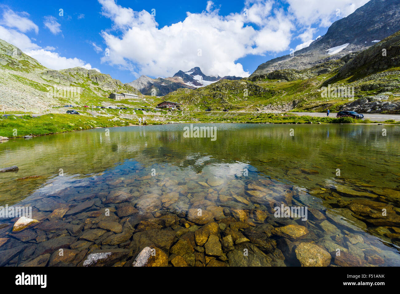 High altitude landscape with mountains, green meadows and a lake at ...