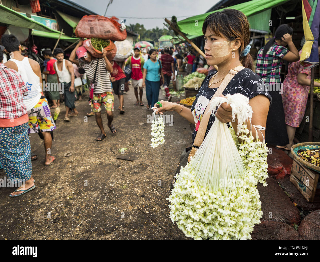 Insein, Yangon Division, Myanmar. 25th Oct, 2015. A woman sells flower ...