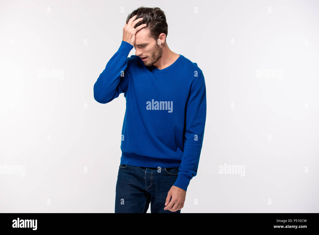 Portrait of a stressed casual man standing isolated on a white ...