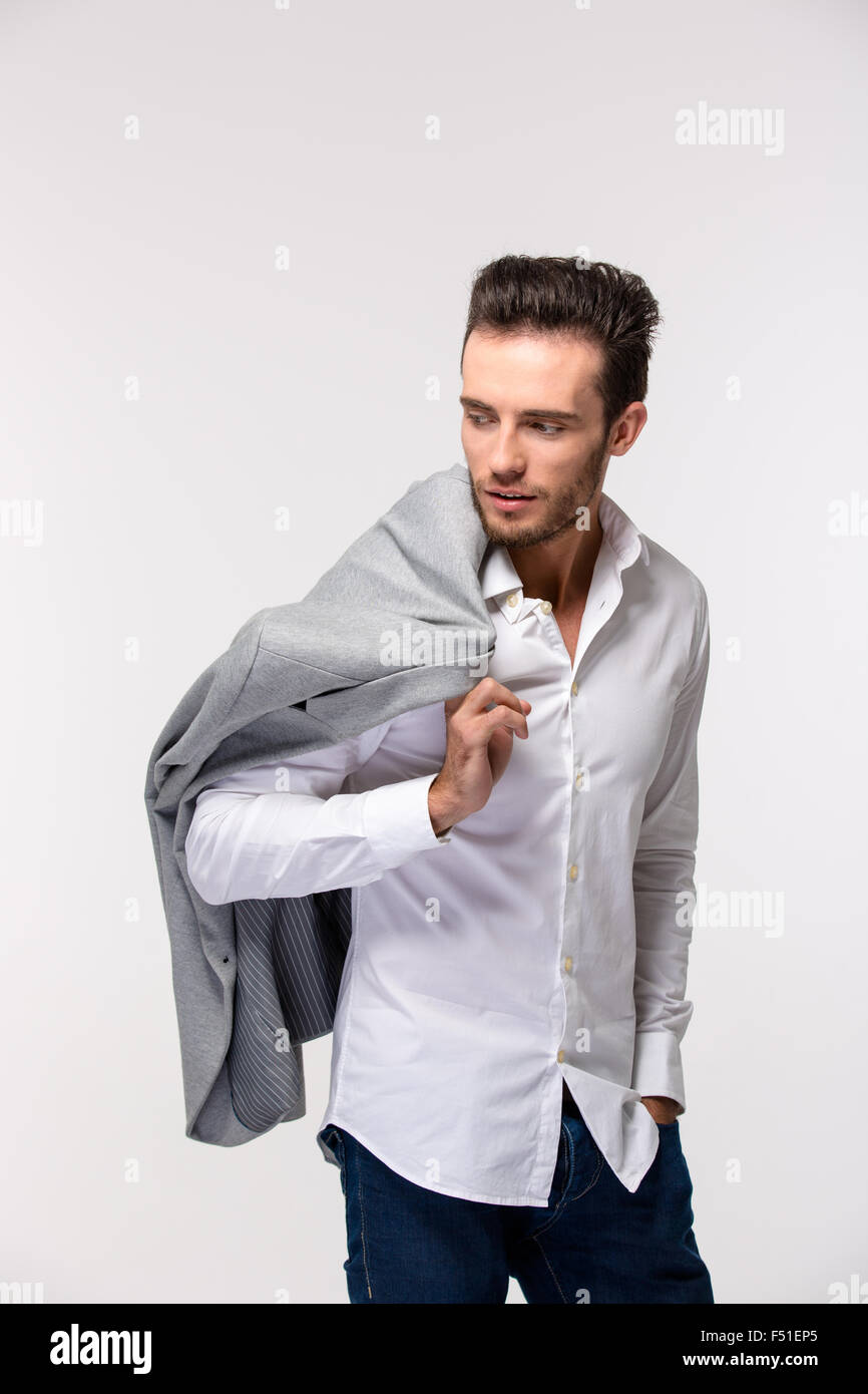 Portrait of a handsome man holding jacket on shoulder and looking away ...