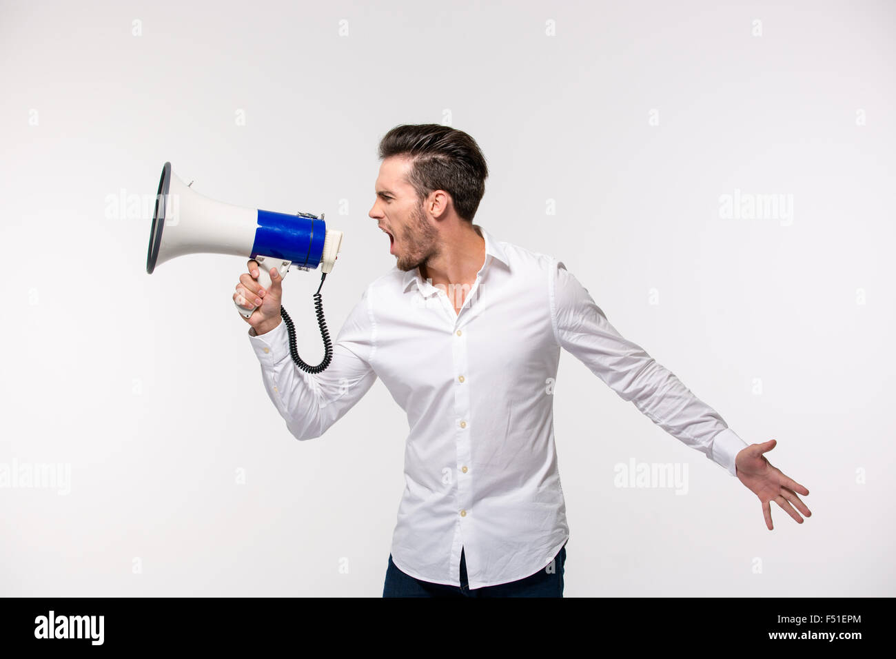 Portrait of a man screaming in megaphone isolated on a white background ...