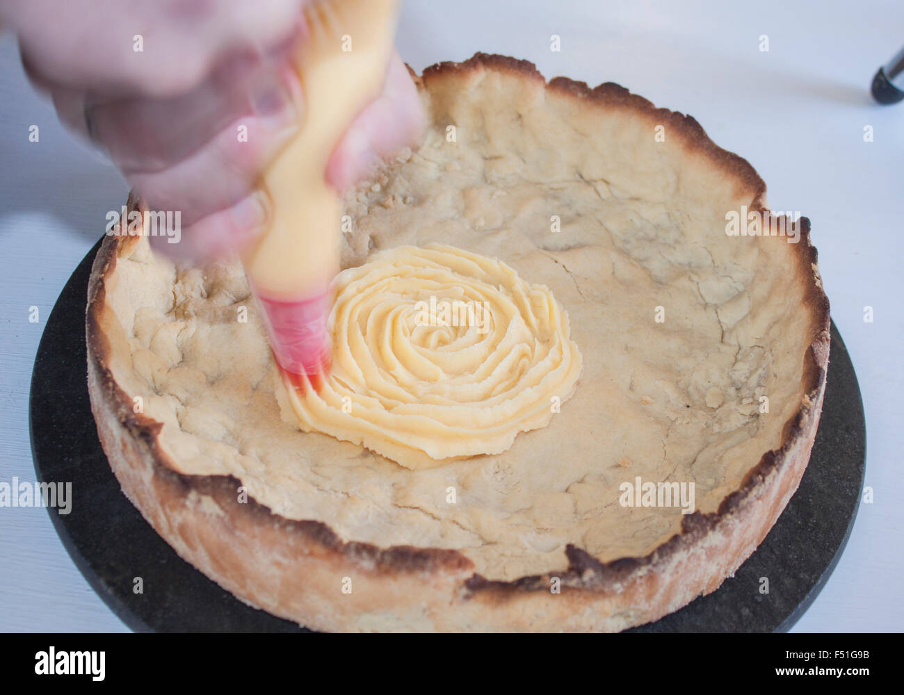 Squeezing lemon curd, on a meringue lemion cake Stock Photo - Alamy