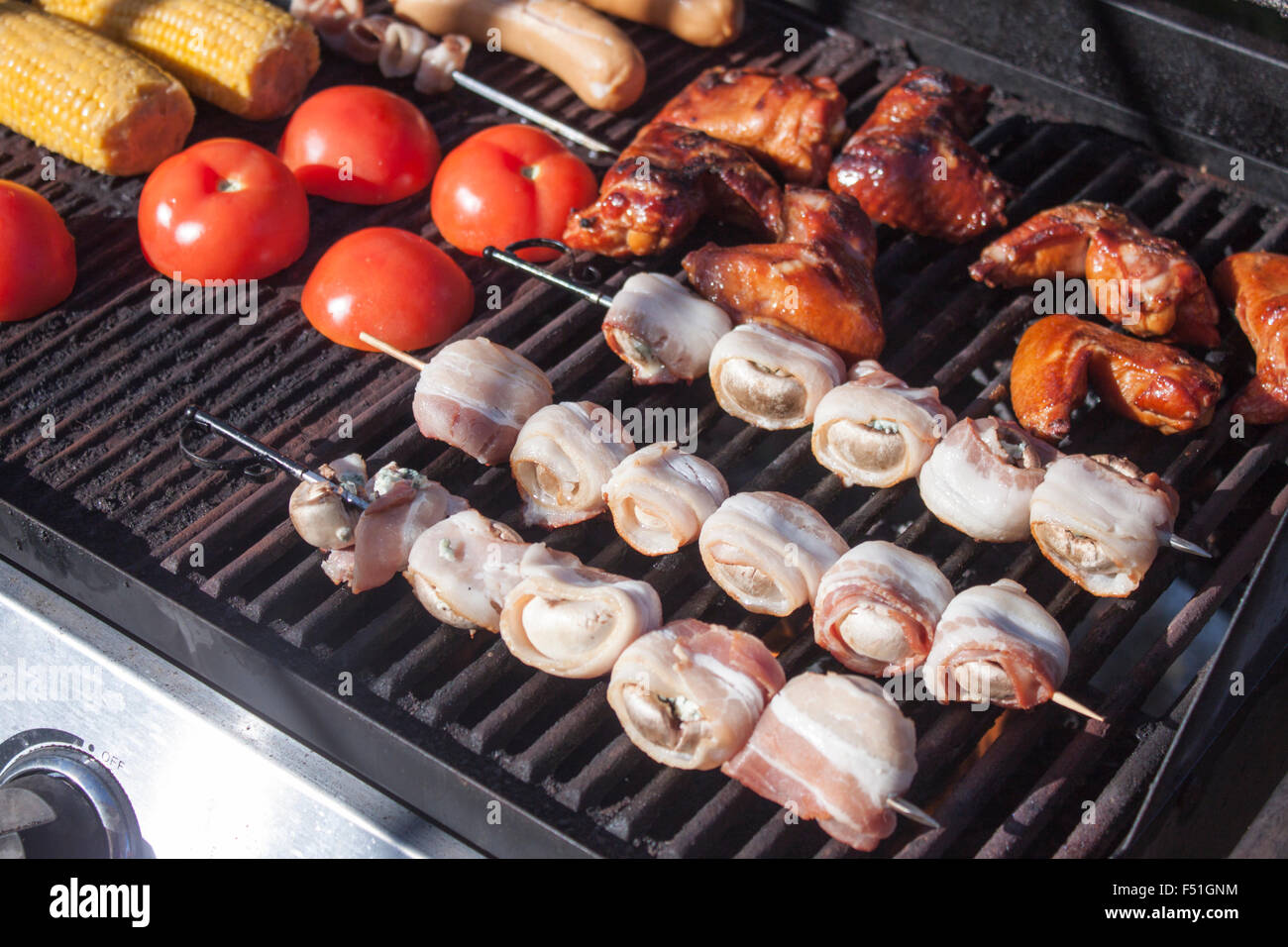 Grilled champignon wrapped in bacon, in between tomatoes, corn and ...