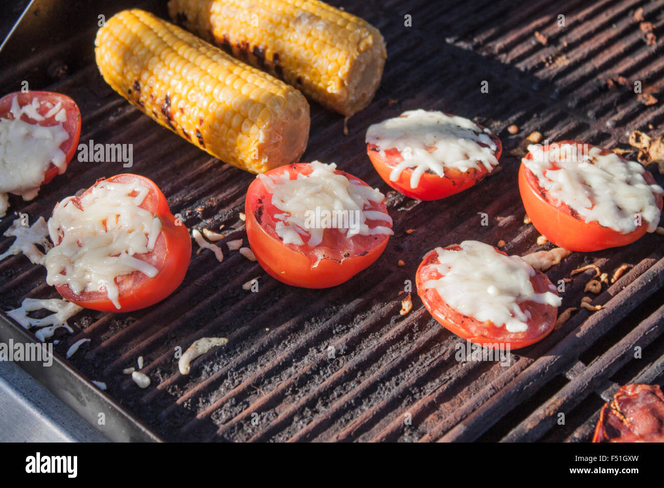 Red grilled tomatoes, between corn and ham. On a barbeque Stock Photo ...