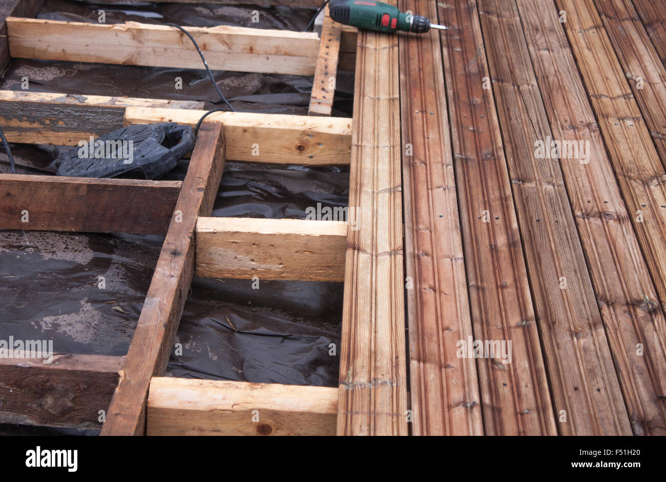 Building a terrace, with a drilling machine and deck screws Stock Photo ...