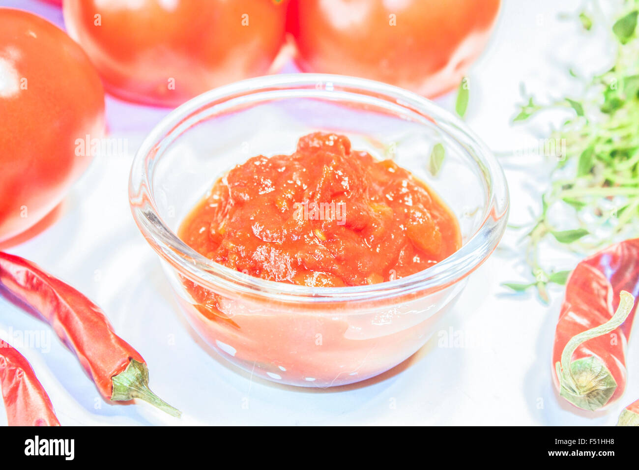 A glass full of colorful salsa sauce, on a white table Stock Photo - Alamy