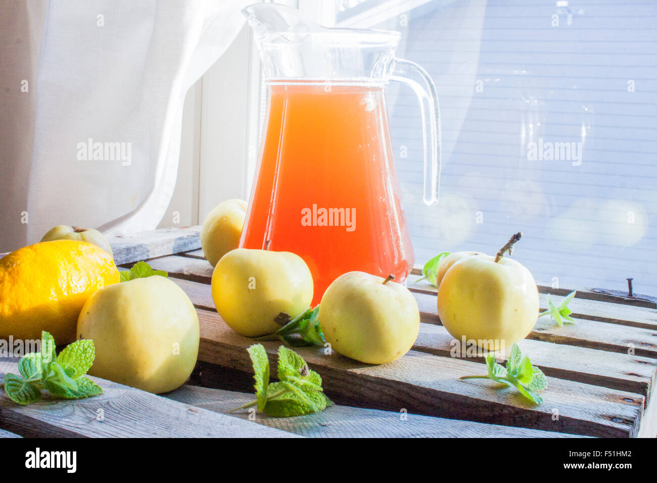 A can full of apple juice, near apples, mint, lemon and lime Stock ...