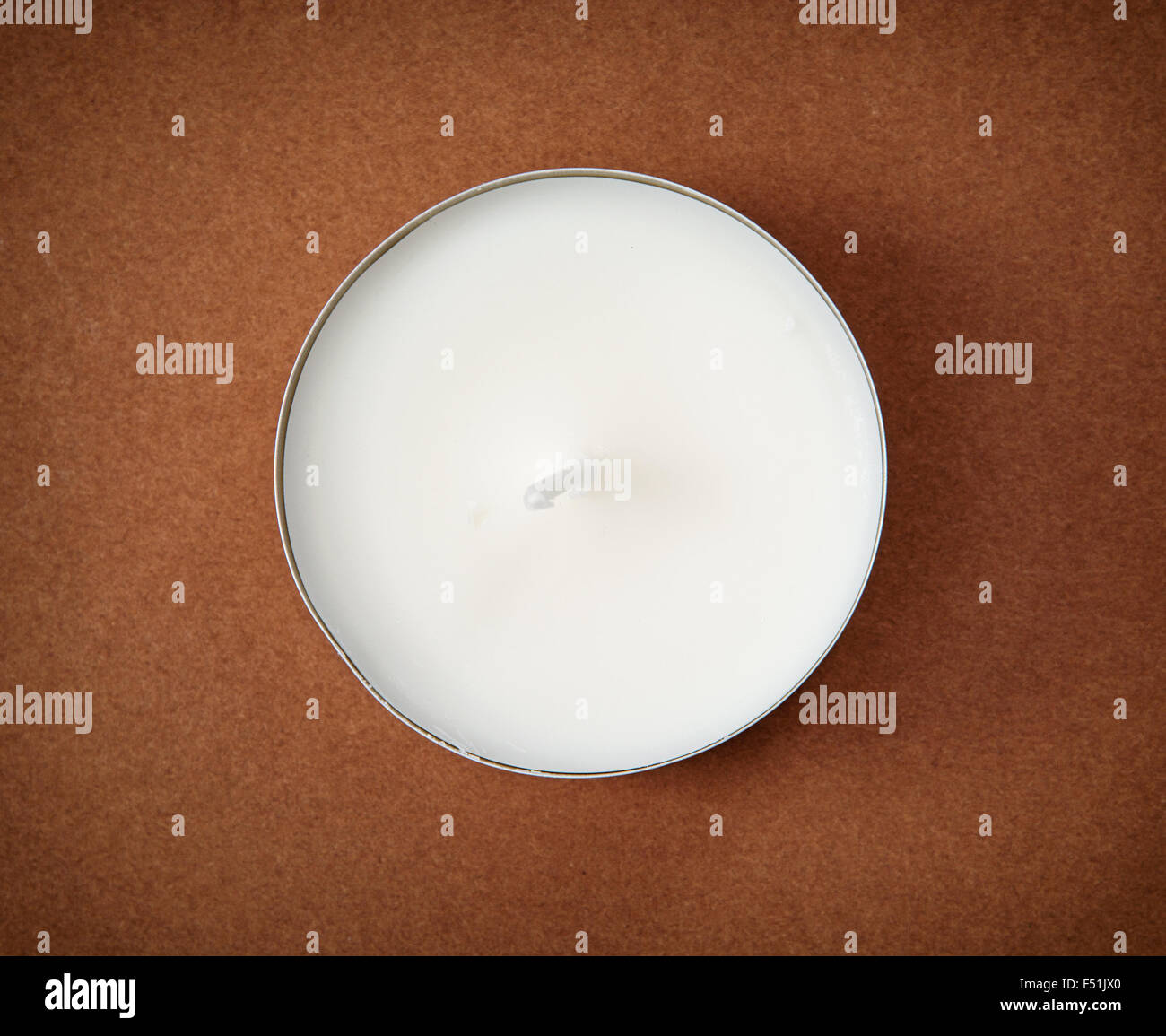 Round candle on the brown background. View from above Stock Photo - Alamy