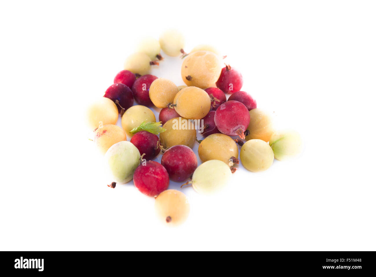 Red, green and yellow frozen gooseberries, isolated on white background ...