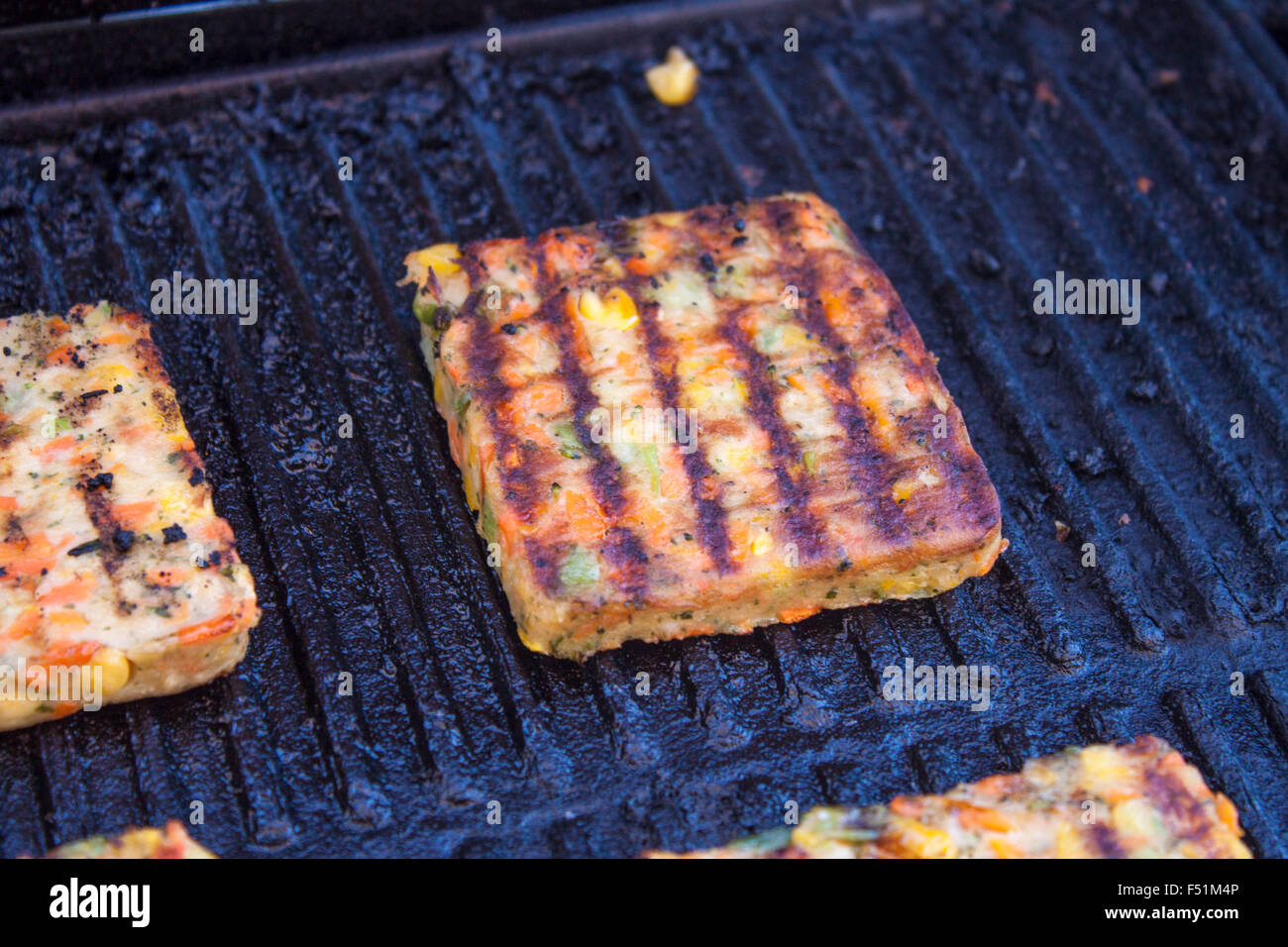Square formed vegetable pattys, on a gas barbeque Stock Photo - Alamy