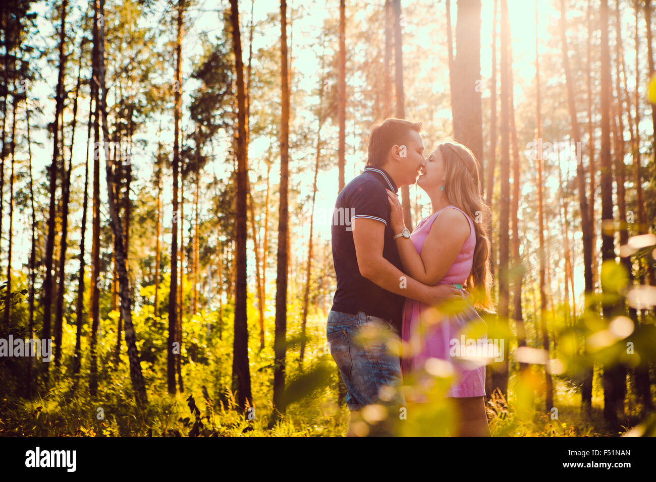 Romantic young couple kissing on background summer forest Stock Photo ...