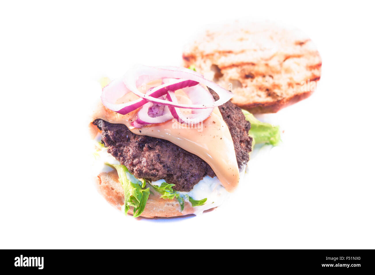 A hamburger with the bun seperated from the burger, built of Cheddar ...