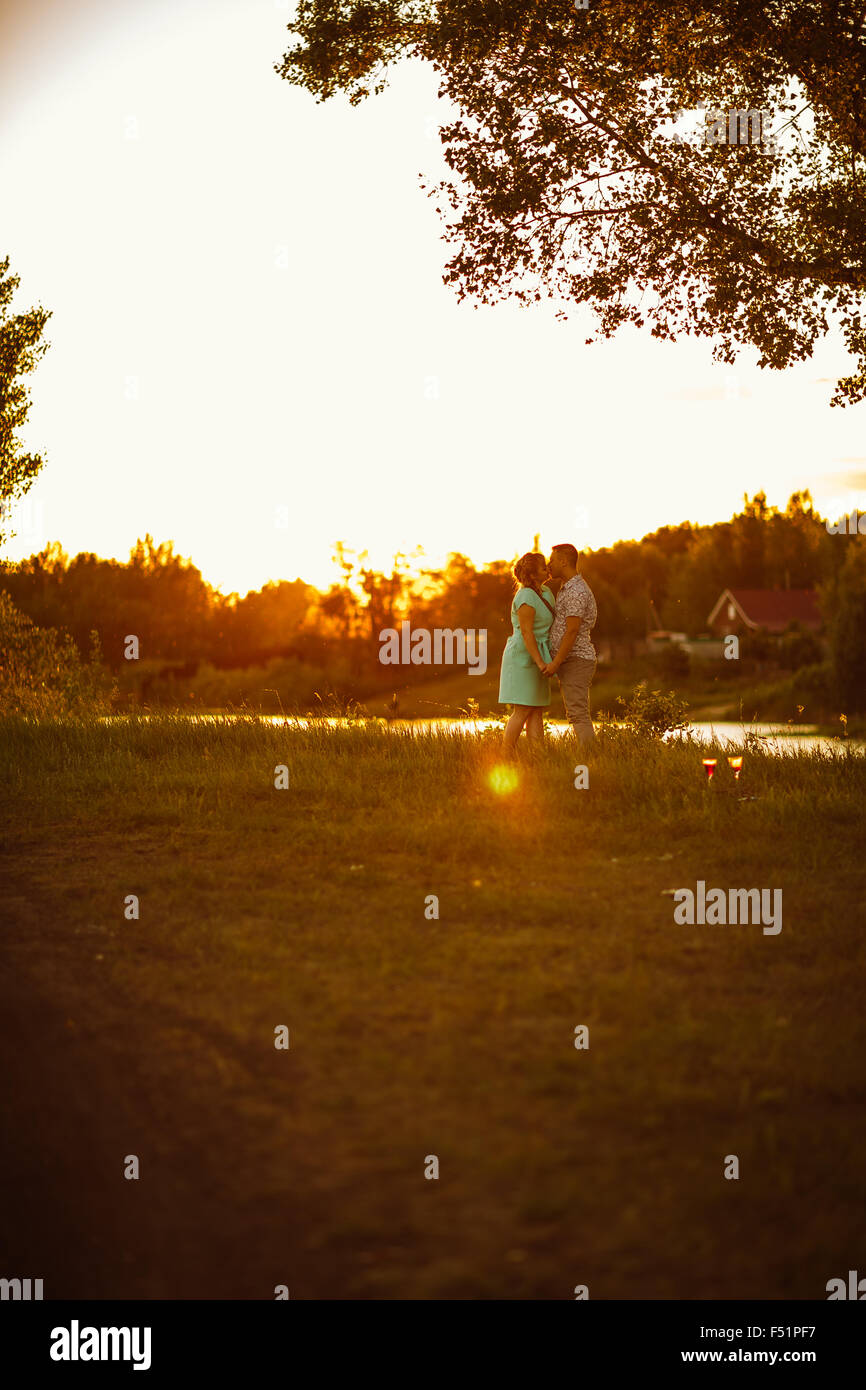 Romantic couple standing and kissing on background summer meadow sunset Stock Photo - Alamy