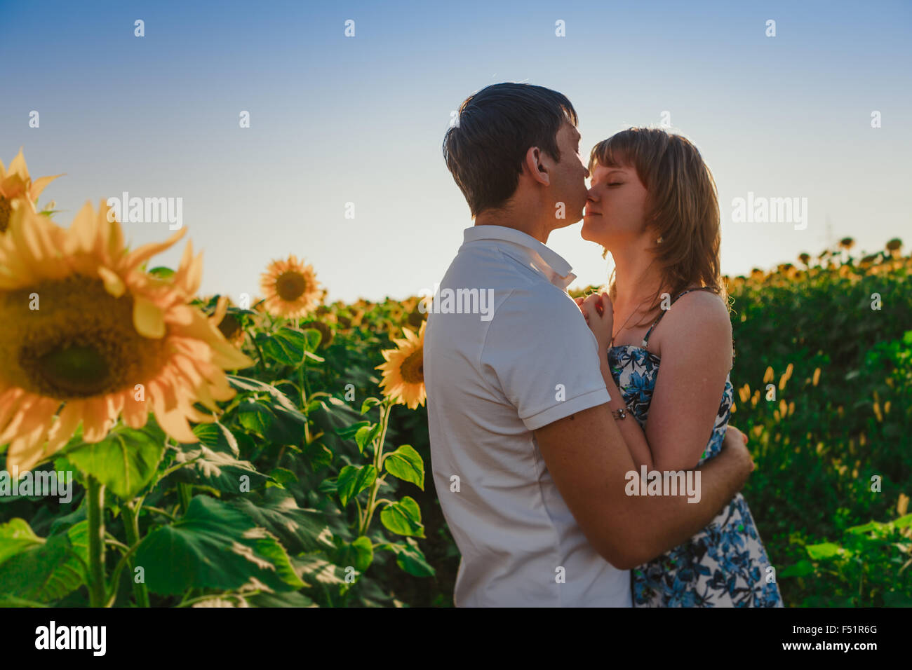 Romantic couple standing and kissing on background summer meadow ...