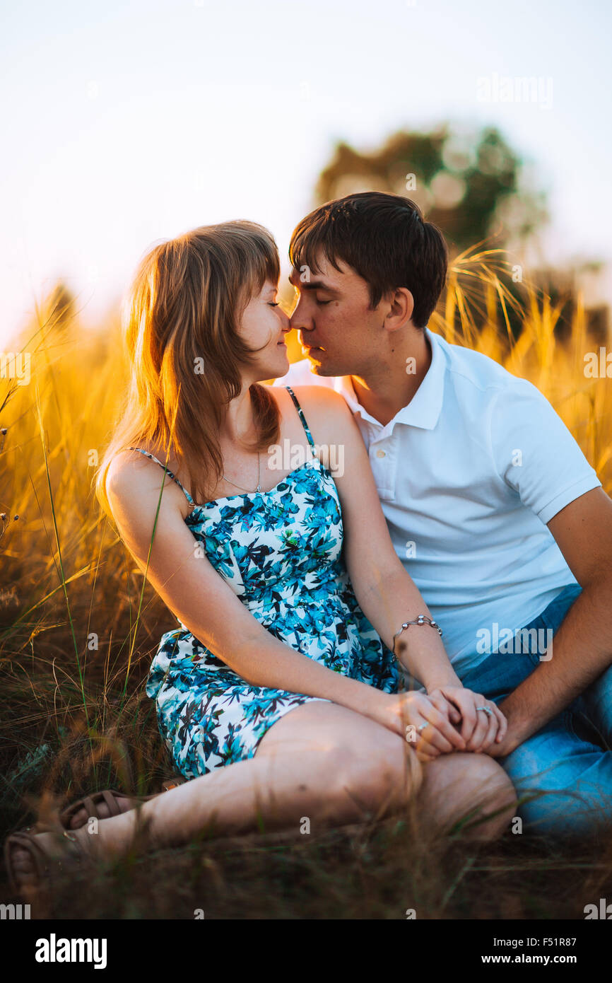 Romantic couple standing and kissing on background summer meadow sunset Stock Photo - Alamy