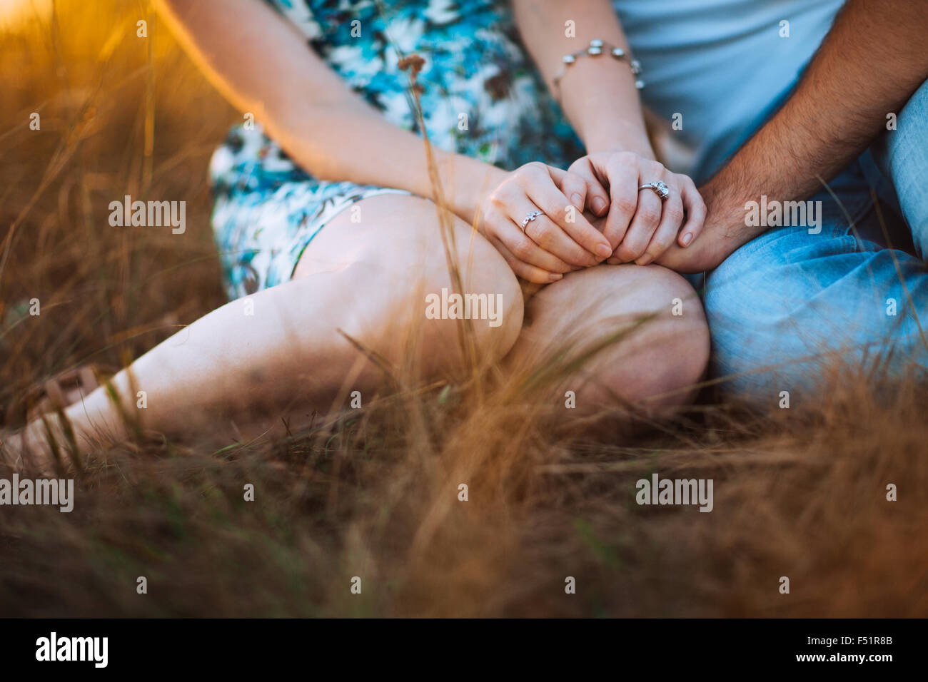 Romantic couple sit on background summer meadow sunset Stock Photo - Alamy