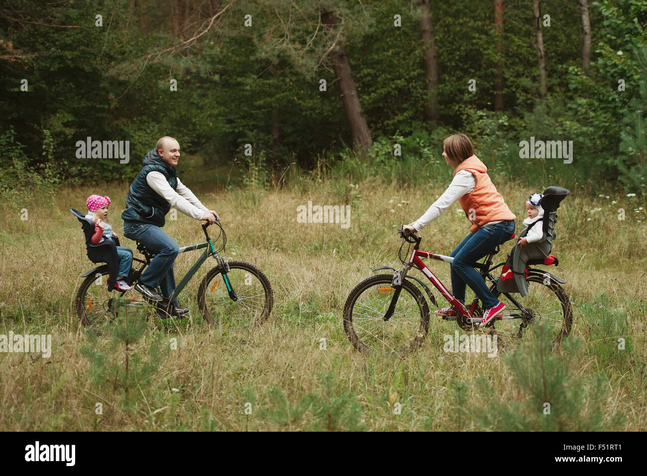 happy family riding bike in wood Stock Photo - Alamy