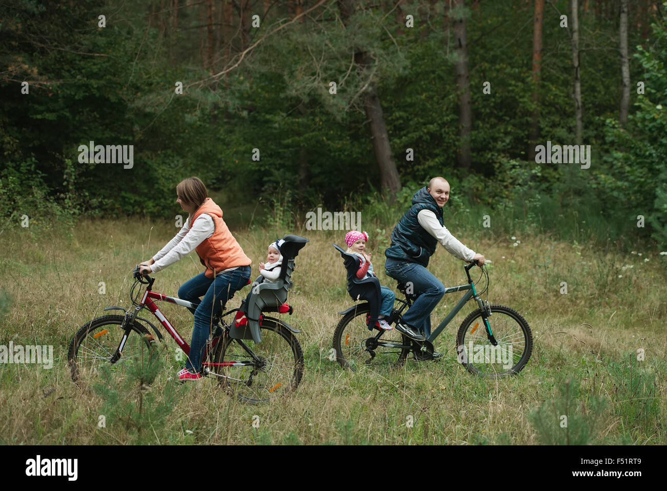 happy family riding bike in wood Stock Photo - Alamy