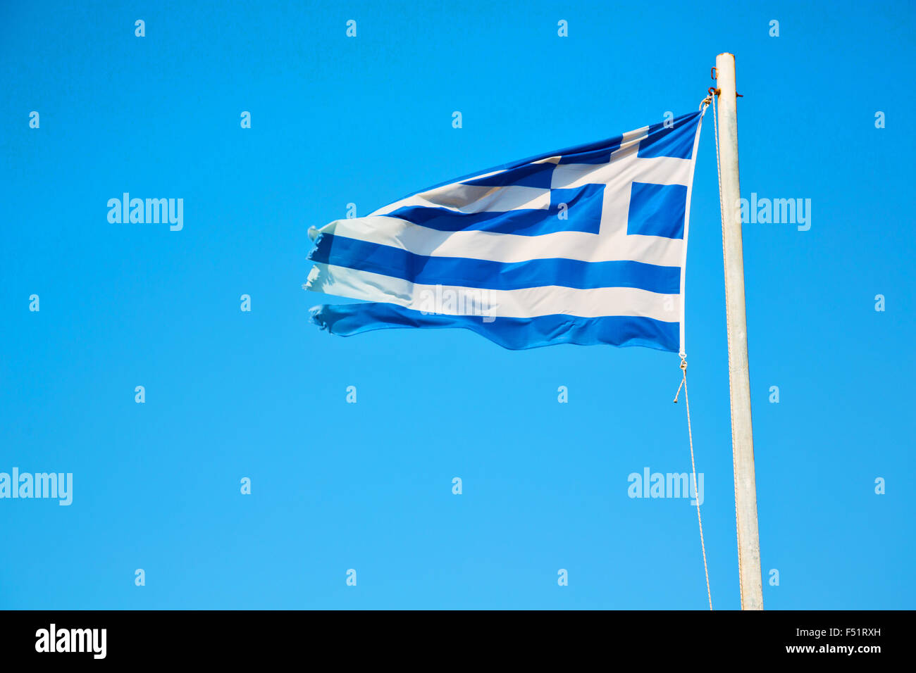 waving greece flag in the blue sky and flagpole Stock Photo - Alamy