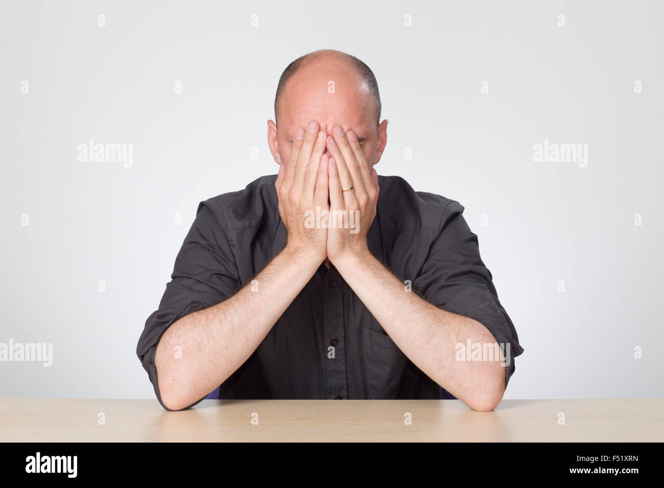 Stressed man sitting at empty desk Stock Photo - Alamy