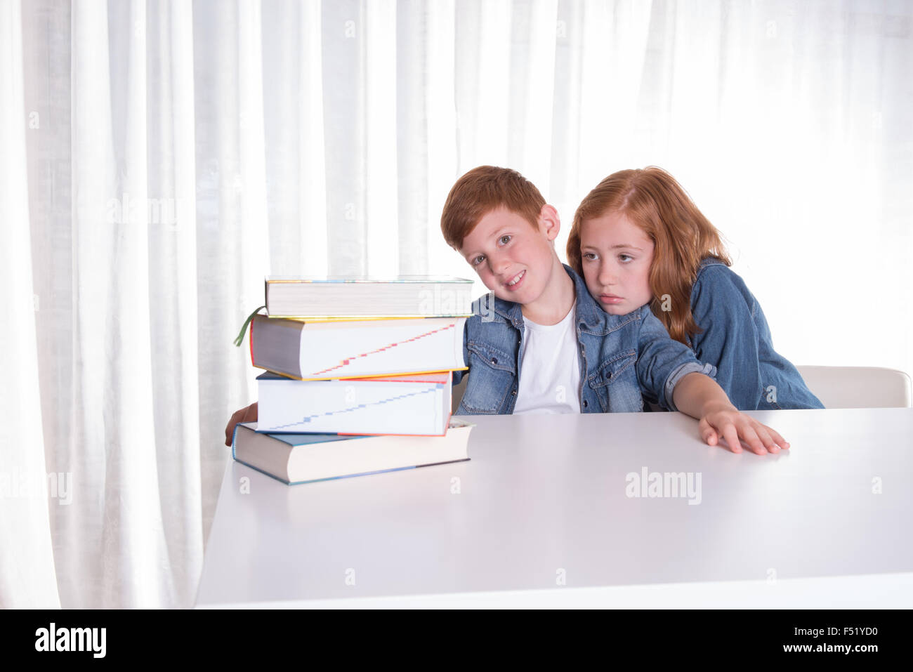 two kids and a pile of books Stock Photo - Alamy