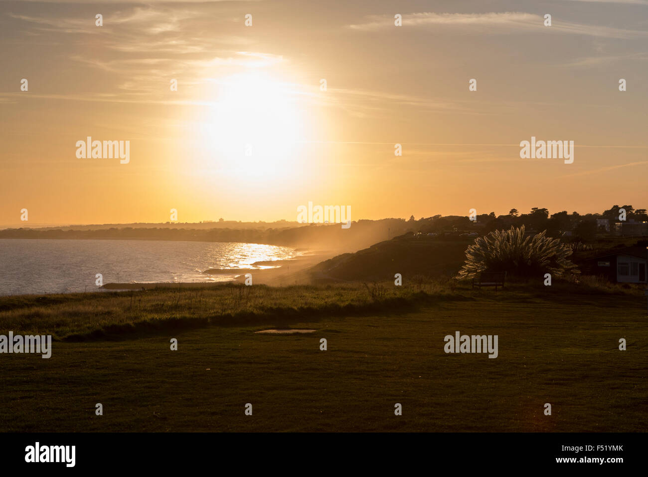 Sunset over land and sea Stock Photo - Alamy