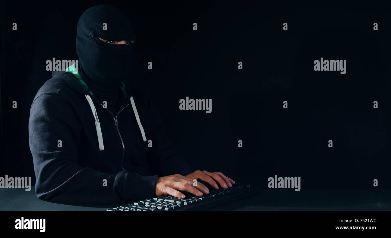 Hacker typing on computer keyboard black background Stock Photo - Alamy
