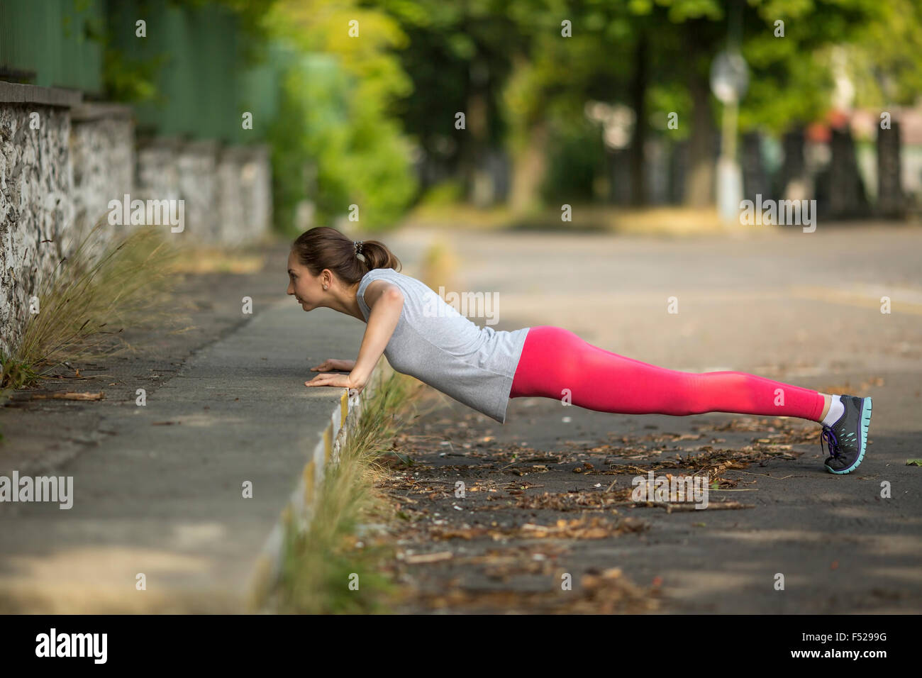 Young athletic woman doing push-ups outdoors Stock Photo - Alamy