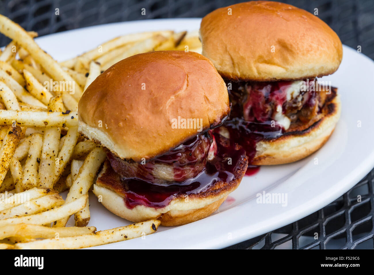 serving of two tenderloin sliders with seasoned shoe string fries Stock ...