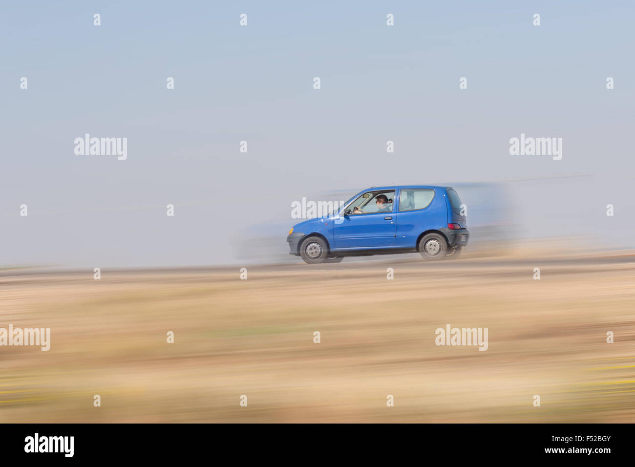 Fast moving blue car Stock Photo - Alamy