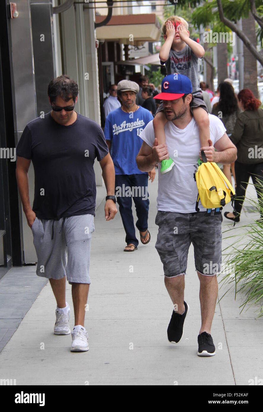 Mike Comrie carries son Luca on his shoulders as the go out and about ...