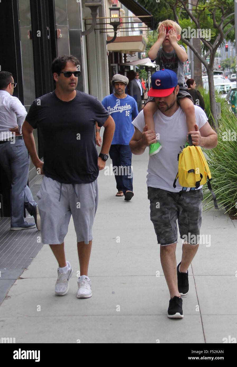 Mike Comrie carries son Luca on his shoulders as the go out and about ...