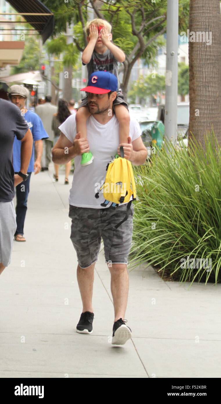 Mike Comrie carries son Luca on his shoulders as the go out and about ...