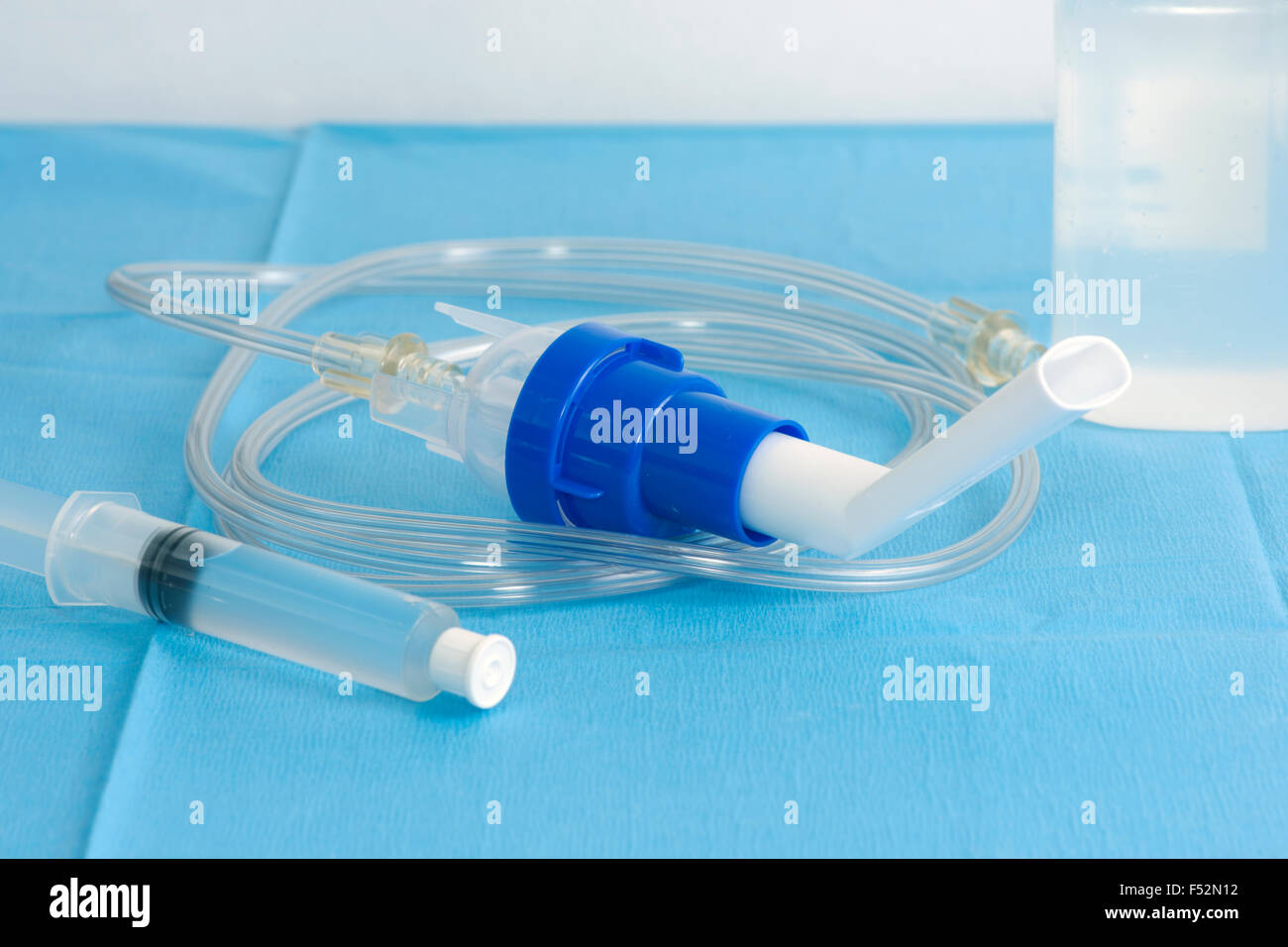 Inhalation therapy chamber and sterile saline syringe on blue sterile ...