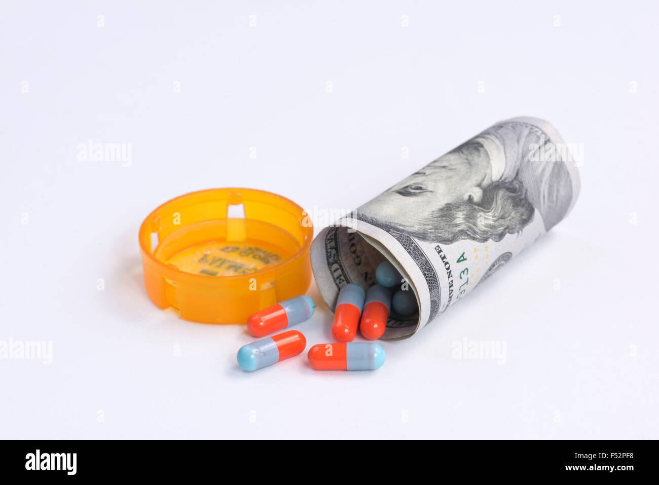 One hundred dollar bill with prescription bottle cap and capsules Stock ...
