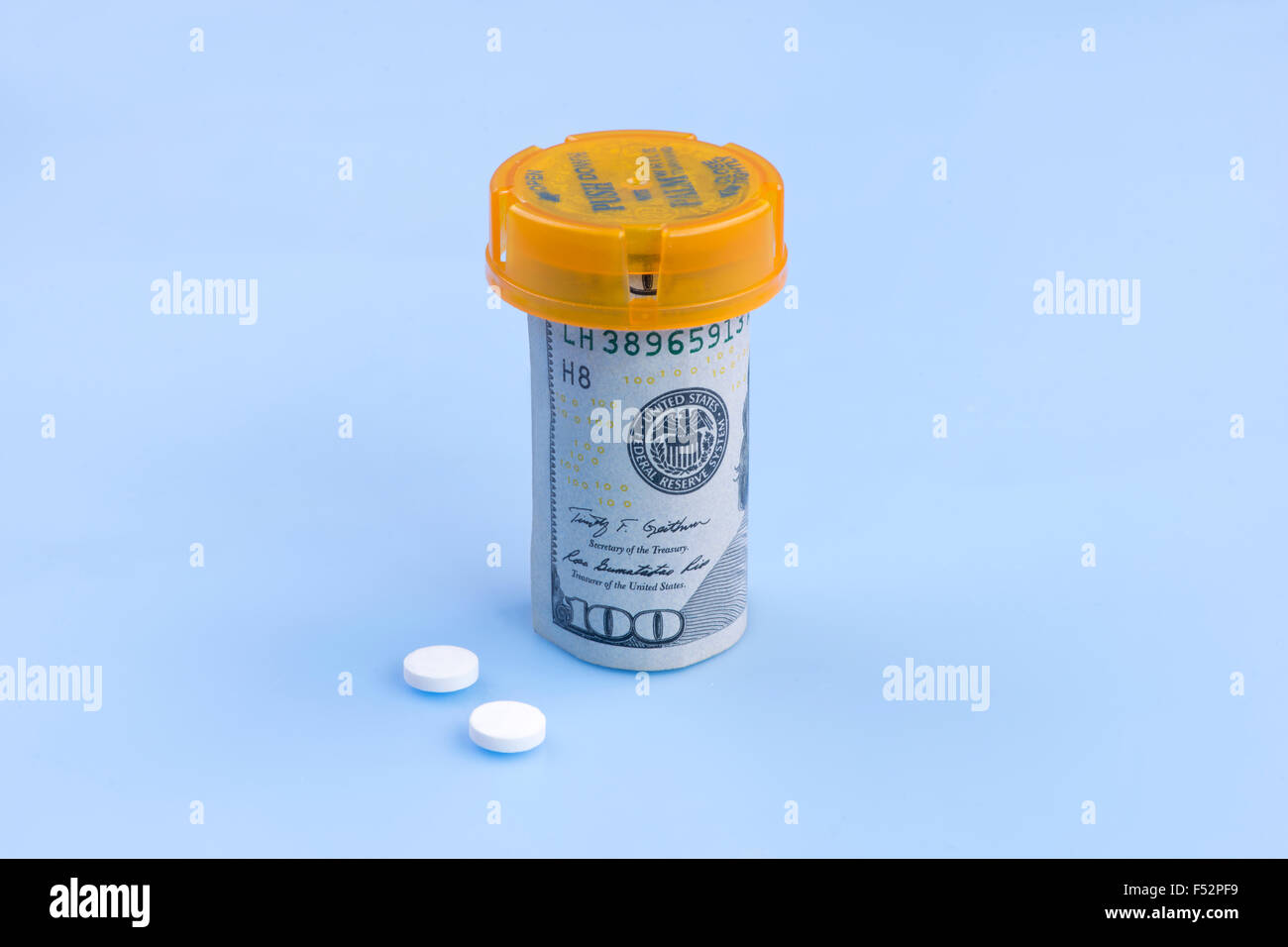One hundred dollar bill with prescription bottle cap and capsules Stock ...