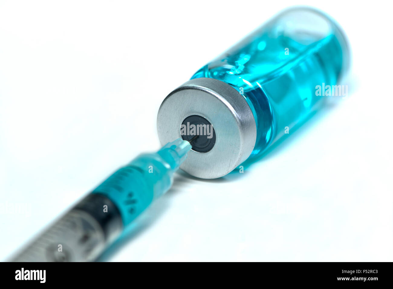 Syringe and vial with blue colored solution Stock Photo - Alamy