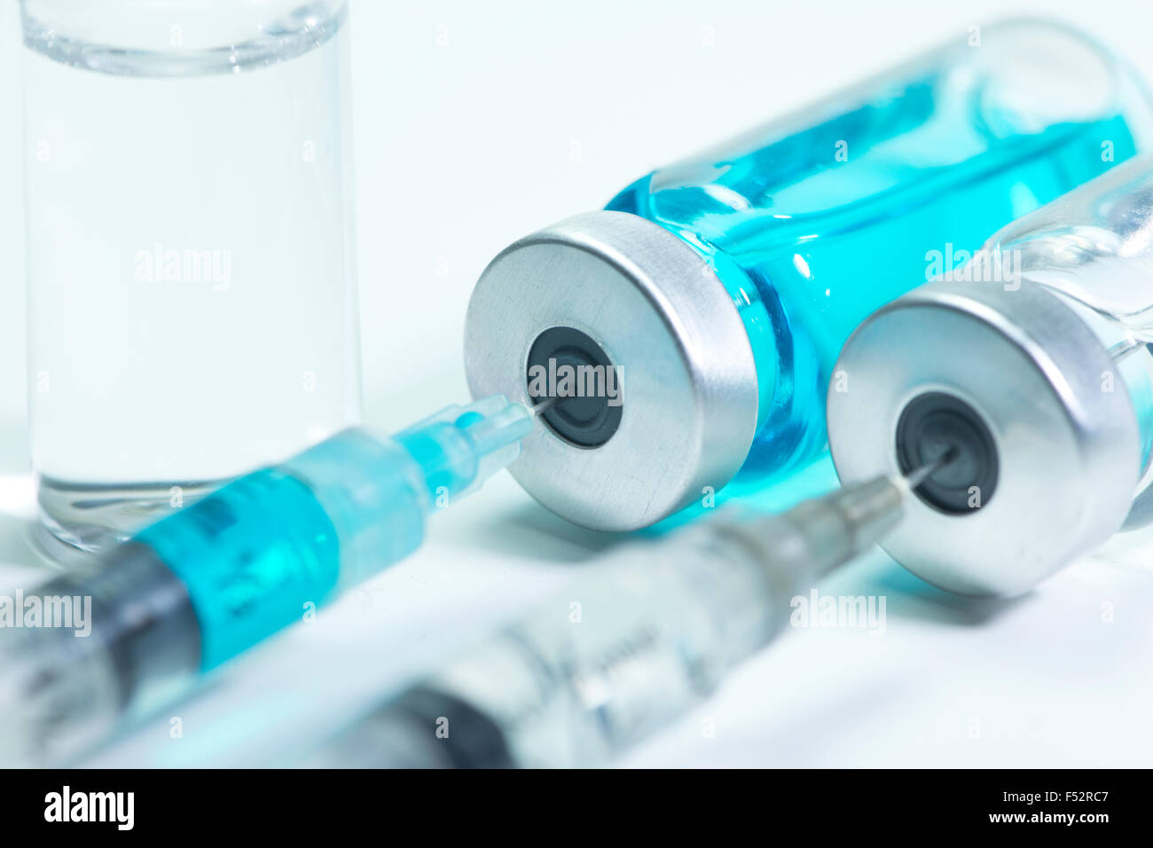 Syringes and vials with clear and blue colored solutions Stock Photo ...